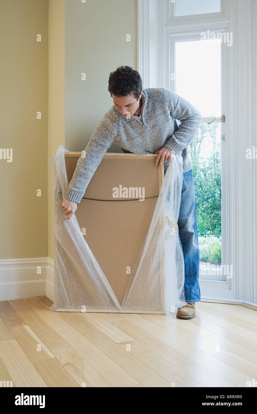 Man unwrapping a picture frame Stock Photo - Alamy