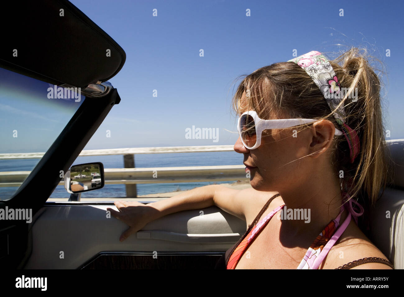 Woman riding in car along coast road, close-up Stock Photo - Alamy