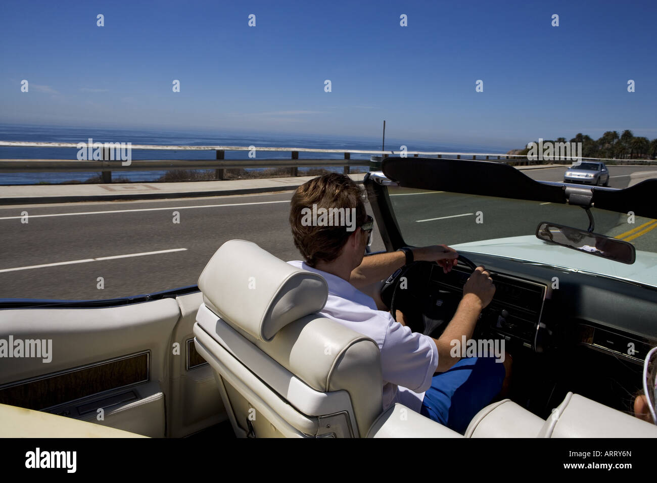 Man driving convertible along coast road Stock Photo - Alamy