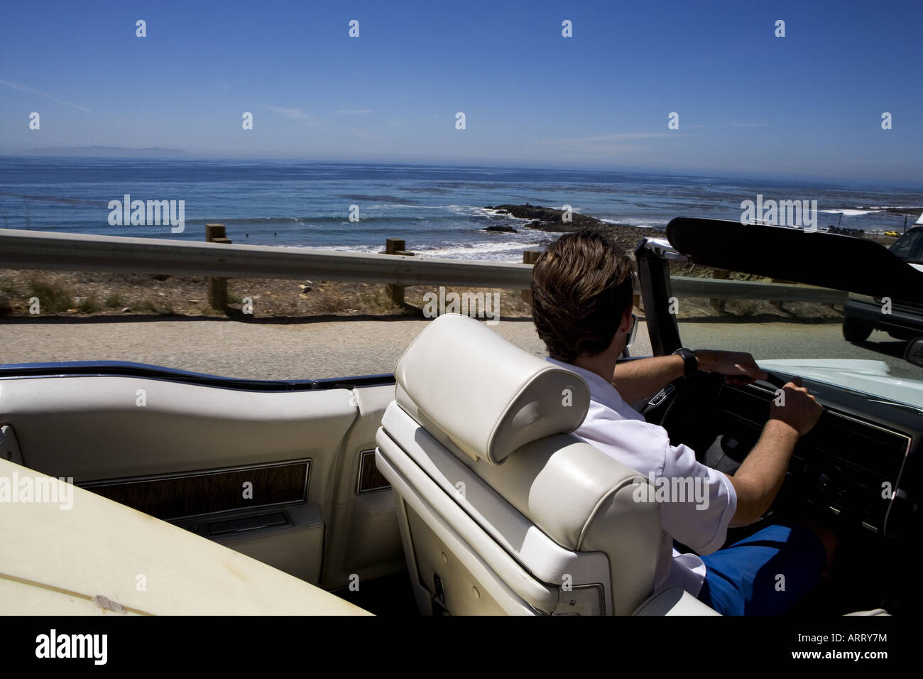 Man driving car along beach Stock Photo - Alamy