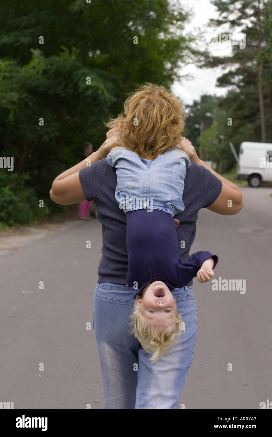 child carried head down Stock Photo - Alamy