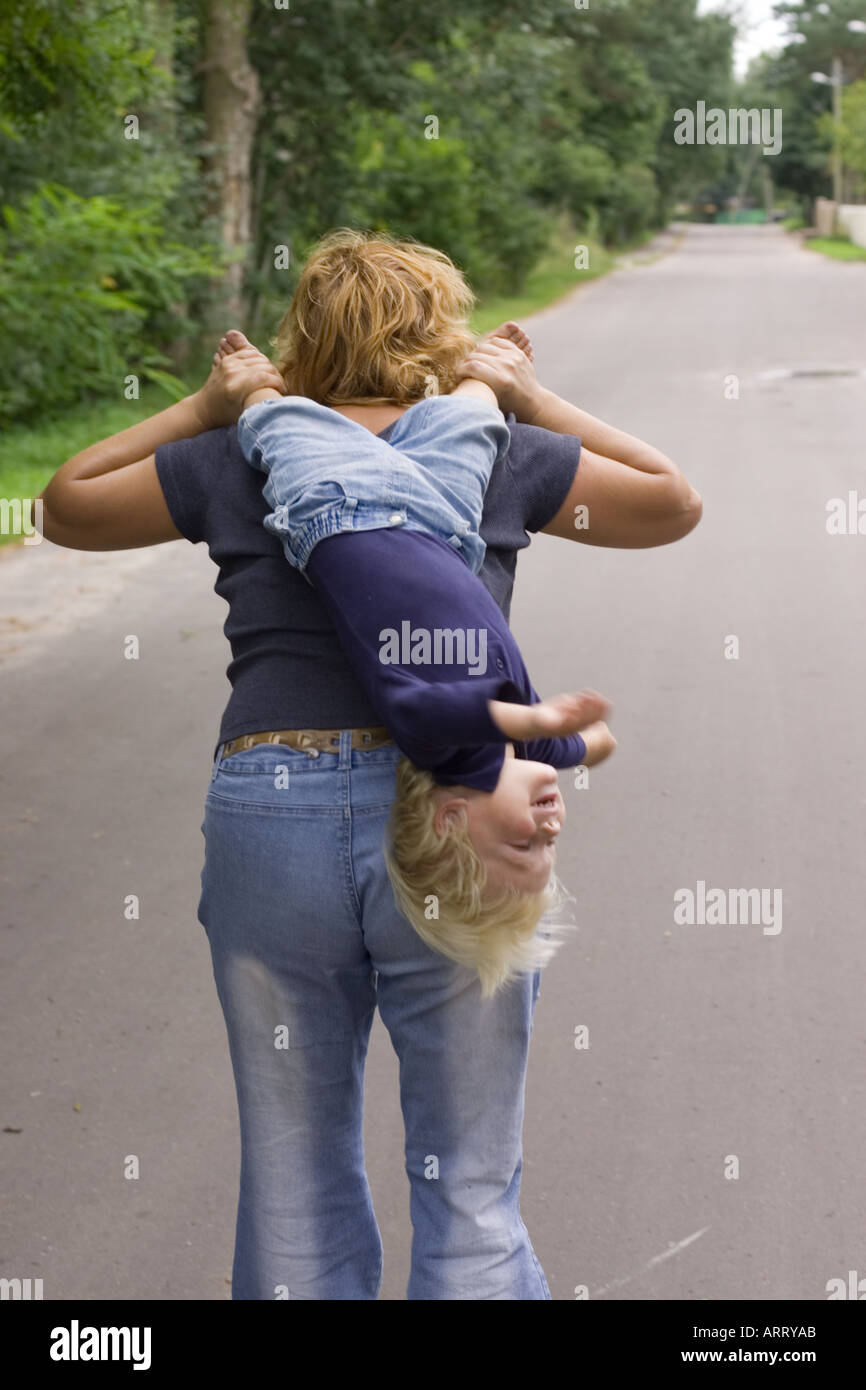 child carried head down Stock Photo - Alamy