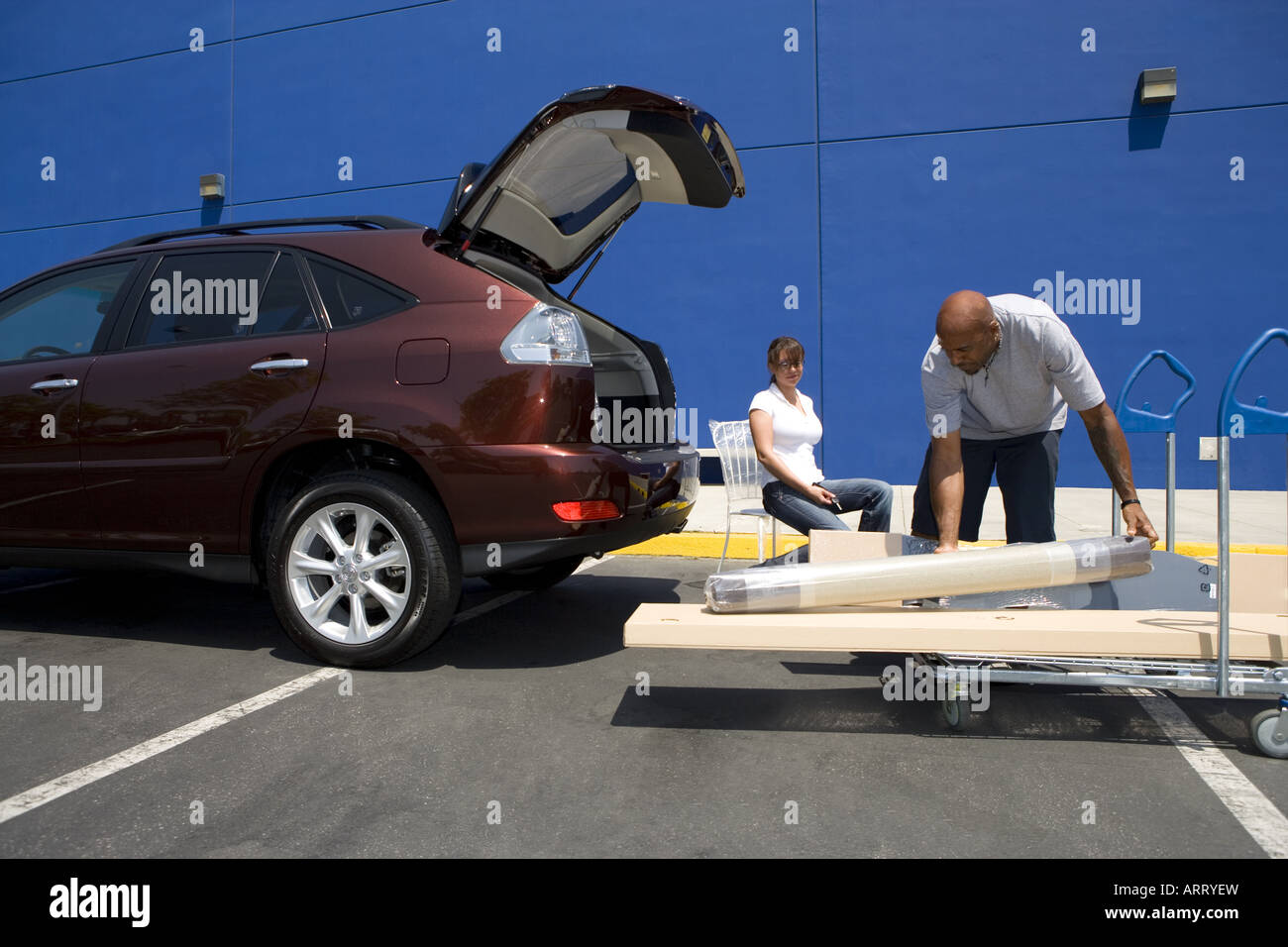 Couple loading items into trunk Stock Photo - Alamy