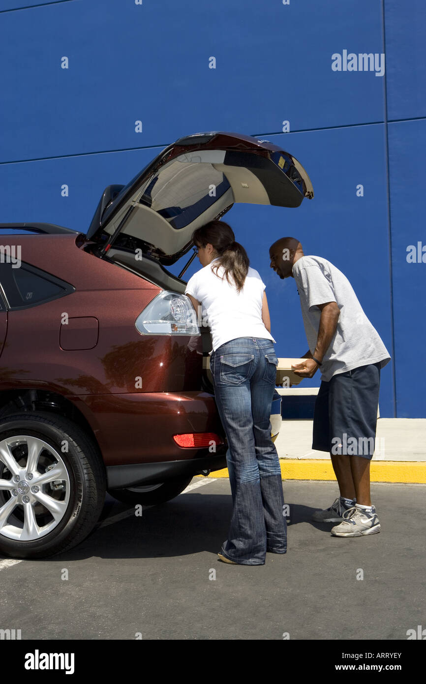 Couple loading items into trunk Stock Photo - Alamy