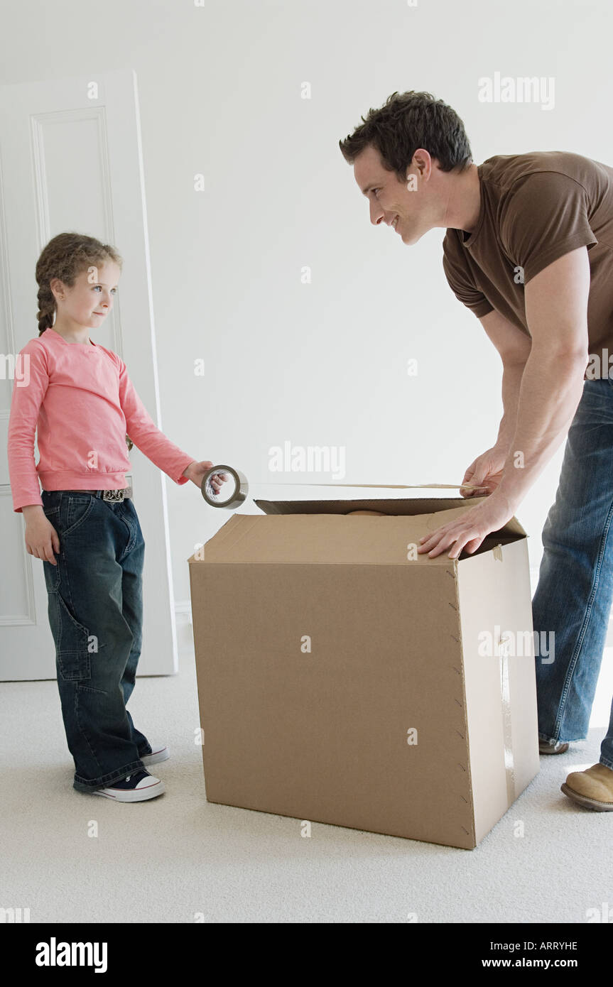 Father and daughter taping up box Stock Photo - Alamy