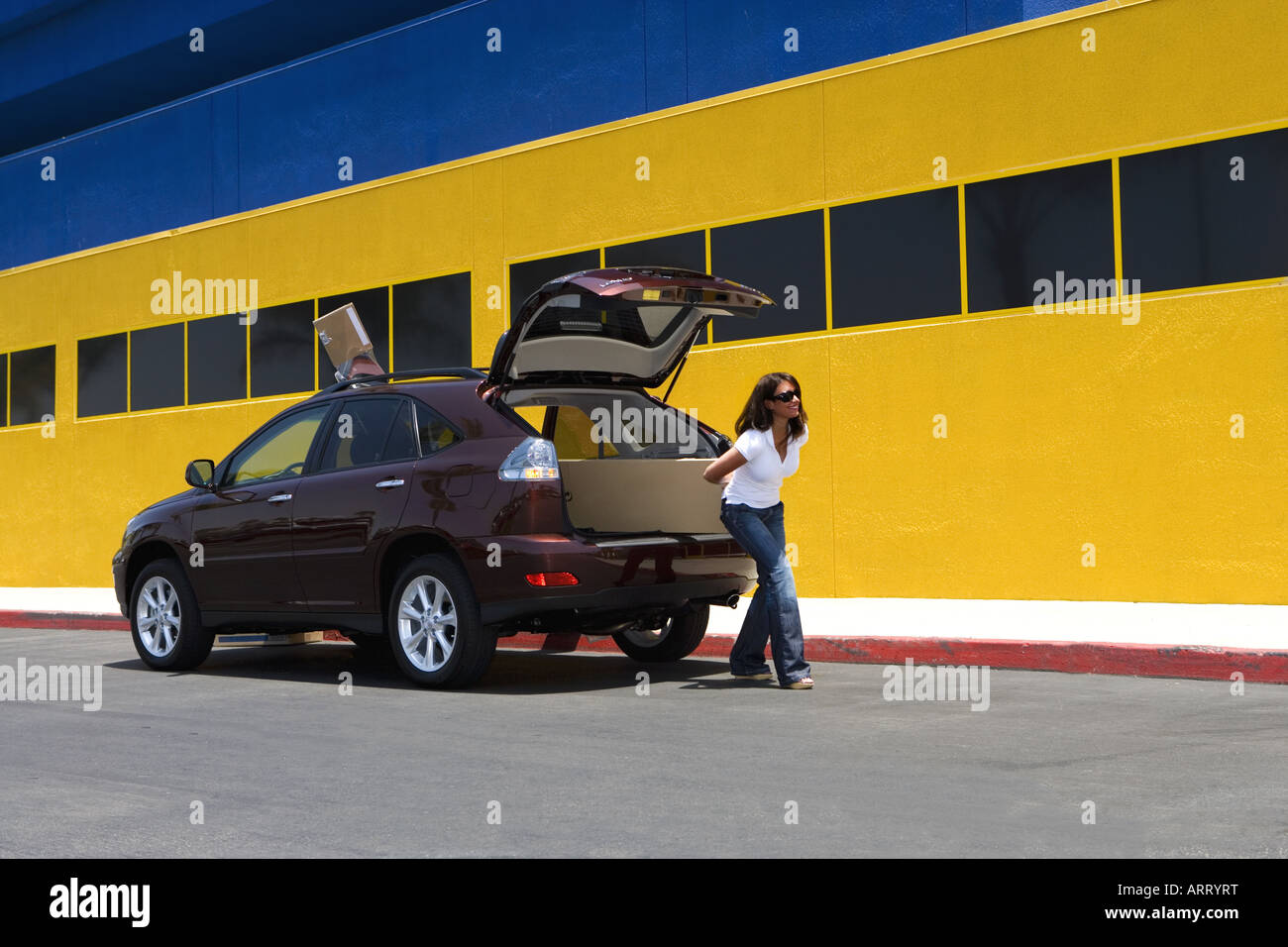 Woman packing boxes into trunk Stock Photo - Alamy