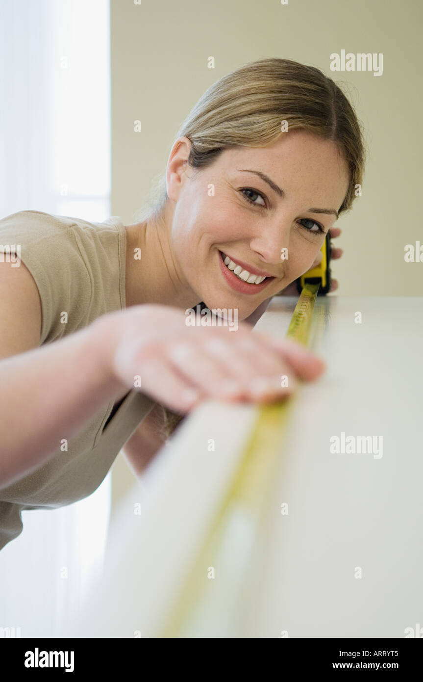 Woman measuring a shelf Stock Photo - Alamy
