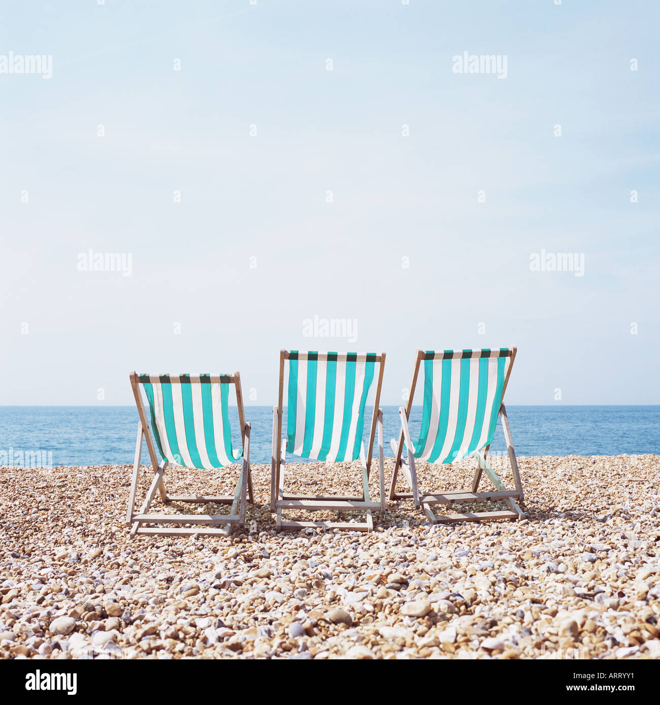 Three deckchairs on a shingle beach Stock Photo - Alamy