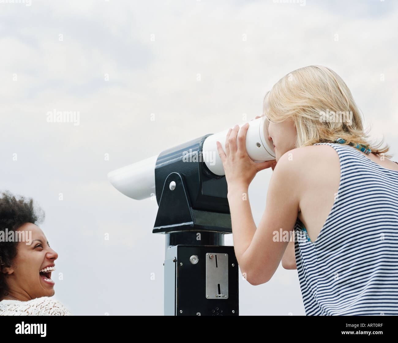 Young women looking through a telescope hi-res stock photography and ...