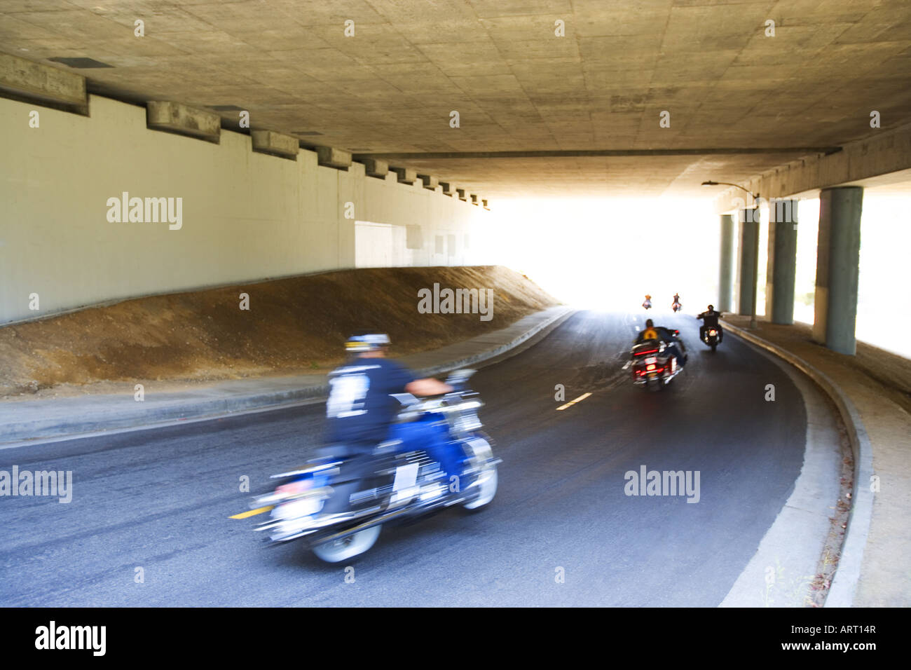 Motorcycles driving under train trestle Stock Photo - Alamy