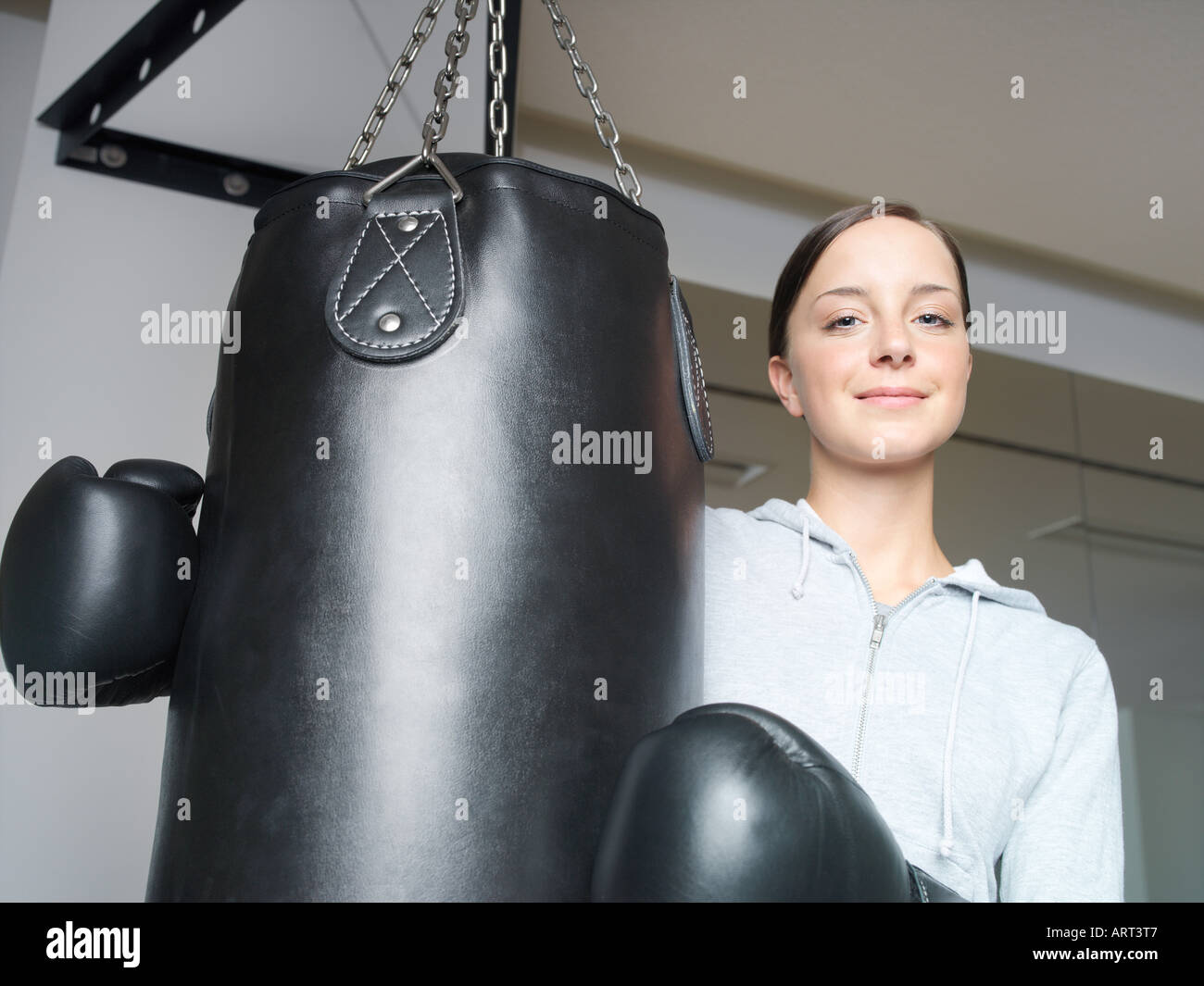 Young female boxer with gloves at punch bag Stock Photo - Alamy