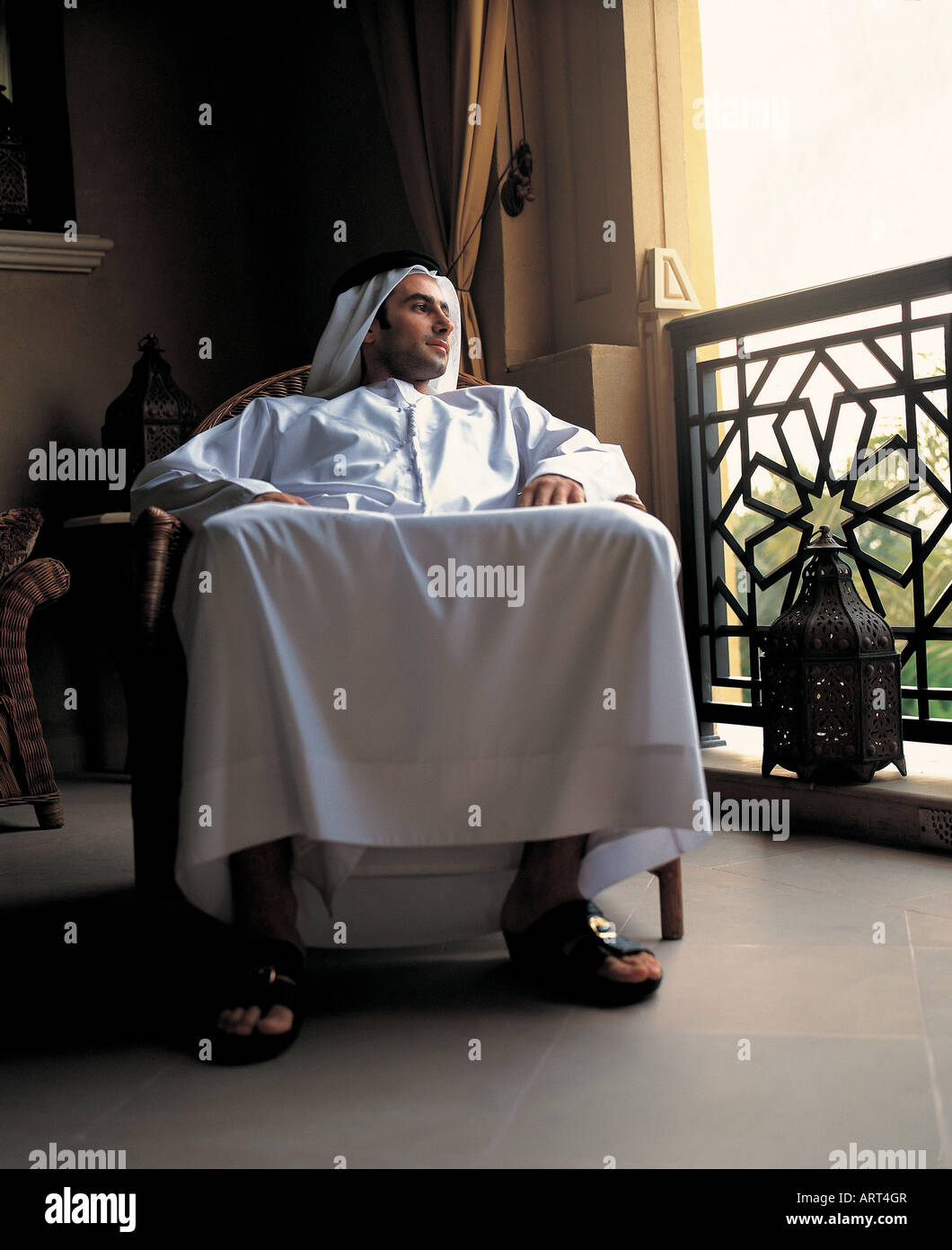 Pensive Arab man looking out of window Stock Photo - Alamy