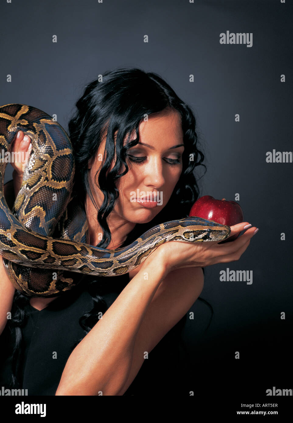 Woman holding a snake and red apple Stock Photo - Alamy