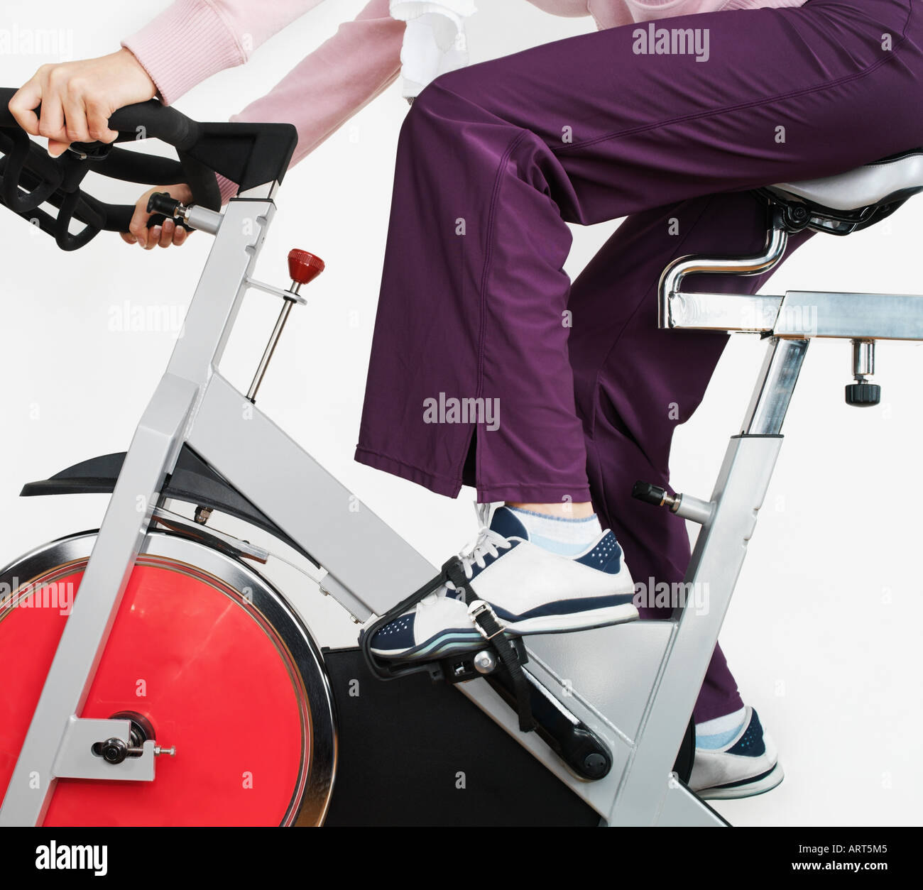 Woman on exercise bike in health club Stock Photo - Alamy