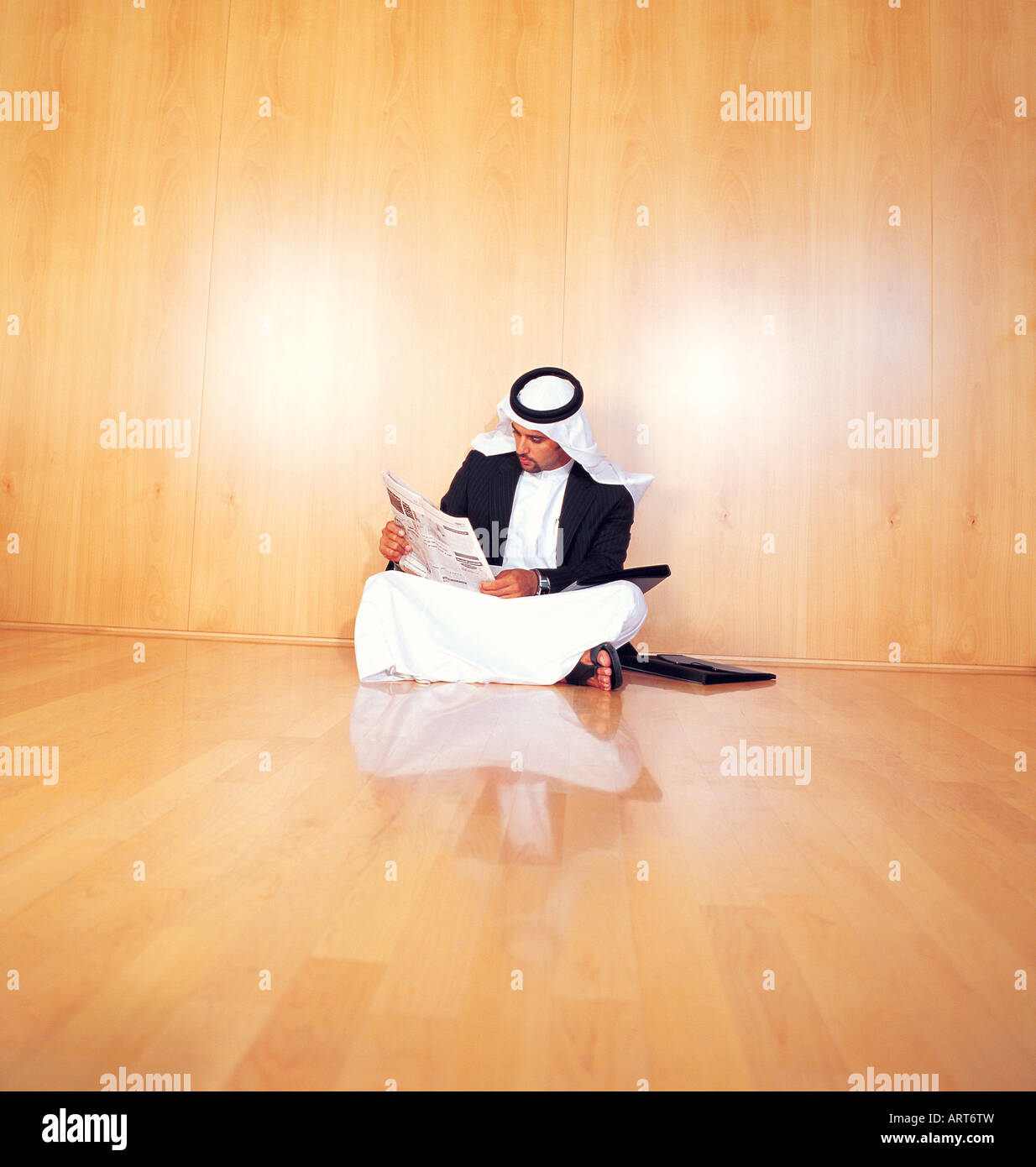 Saudi Arabian businessman reading newspaper Stock Photo - Alamy