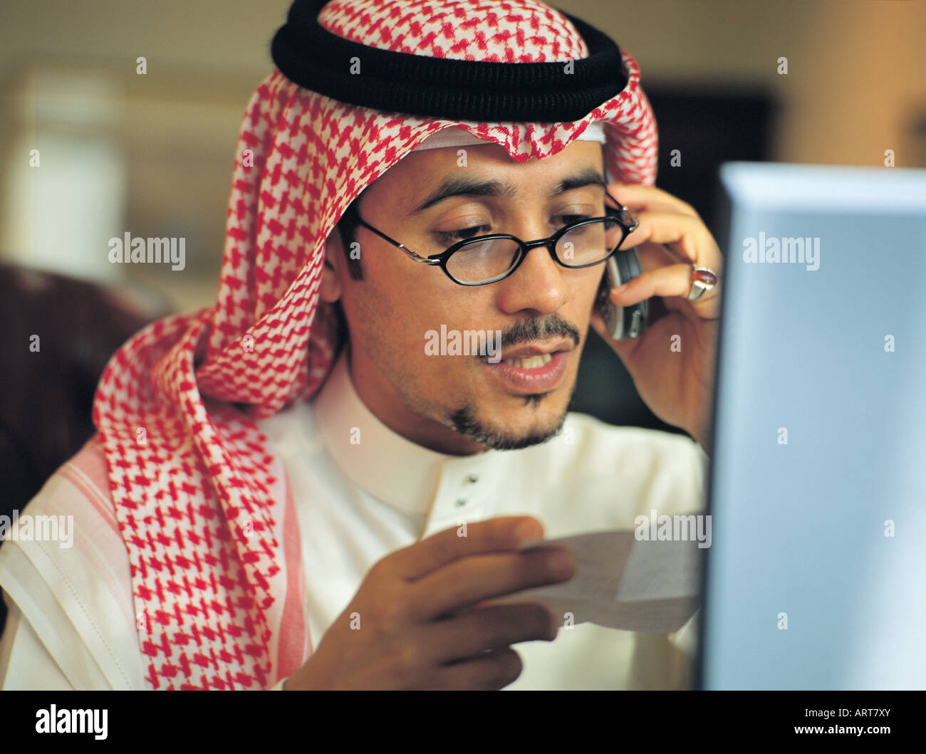 Saudi businessman using mobile phone and laptop Stock Photo - Alamy