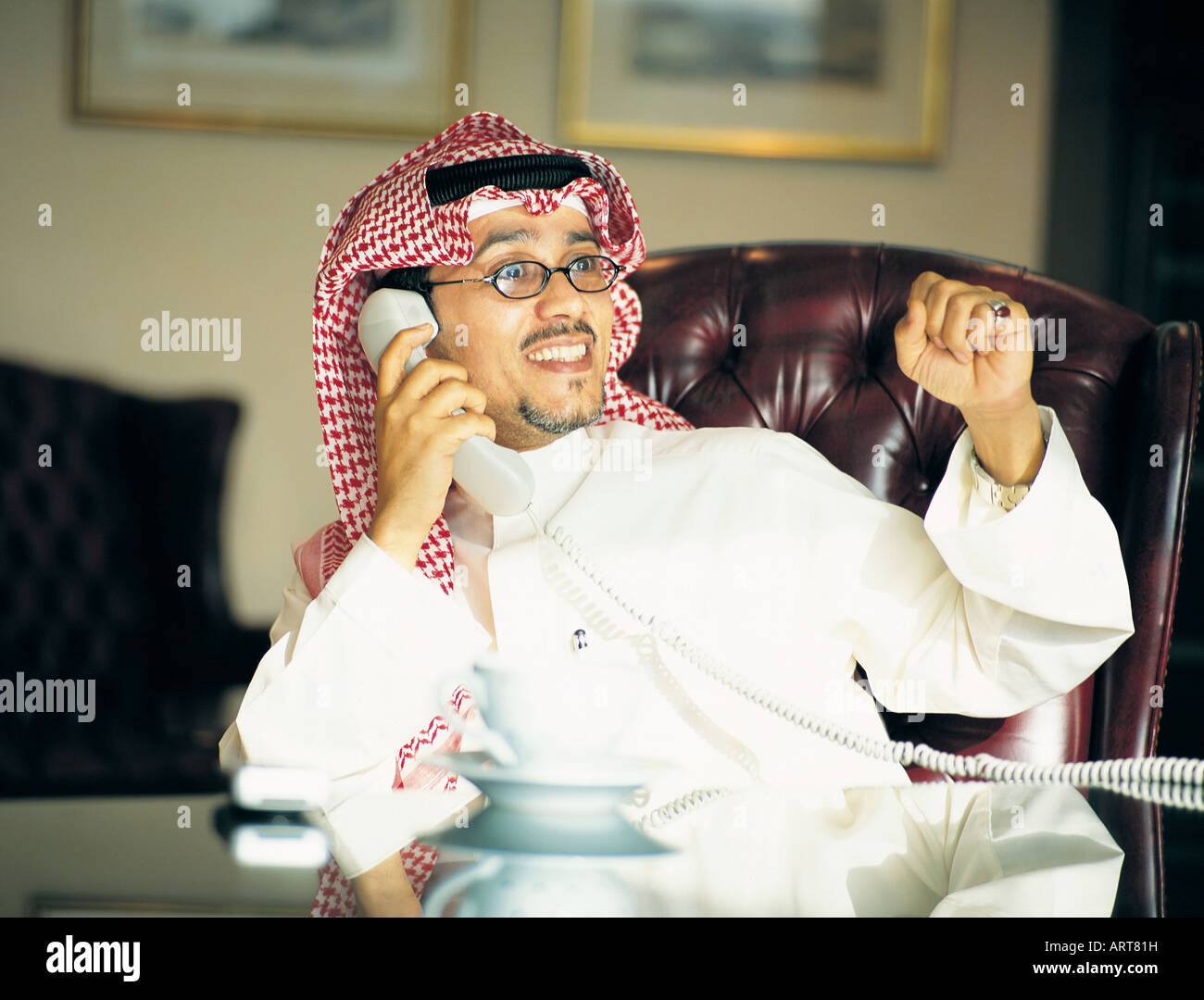 Saudi businessman celebrating success while using a telephone Stock ...
