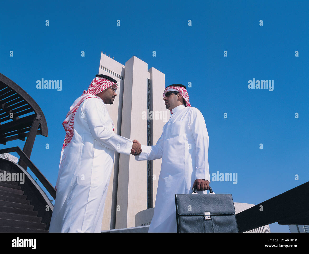Saudi businessmen shaking hands in front of NCB building, Jeddah, Saudi ...