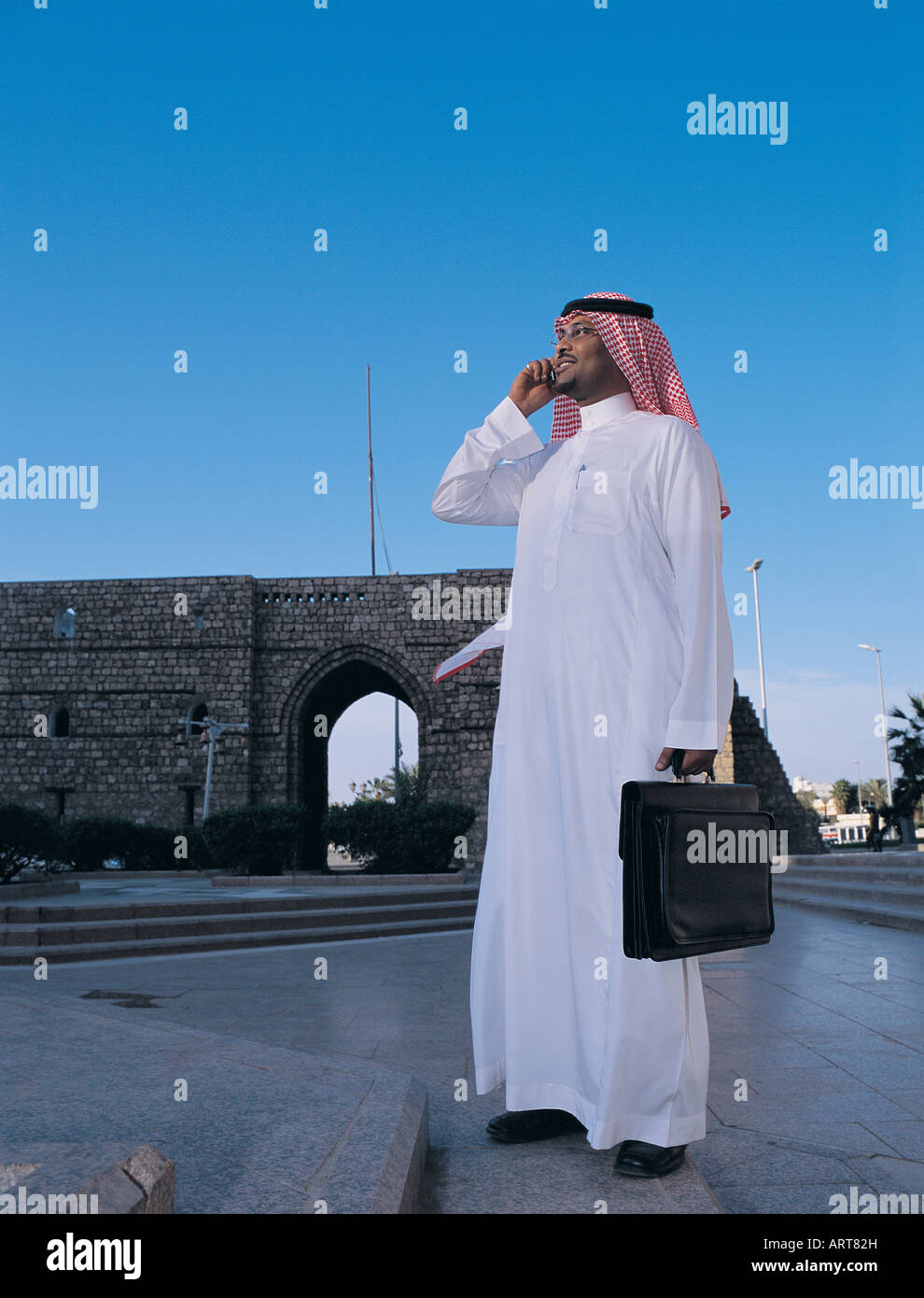 Saudi man using mobile phone near ancient gate of Old Town in Jeddah ...