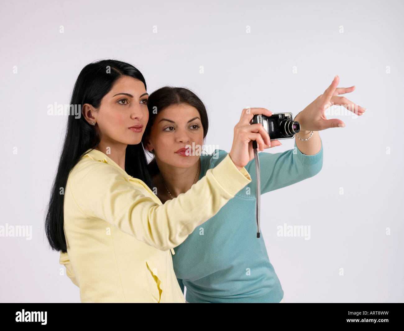 Female friends taking pictures with a camera Stock Photo - Alamy