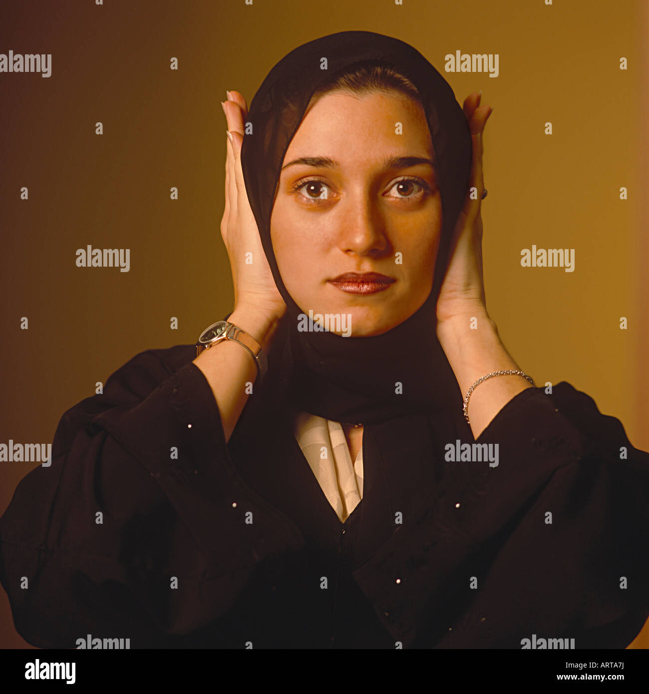 Arab woman covering her ears with her hands Stock Photo - Alamy