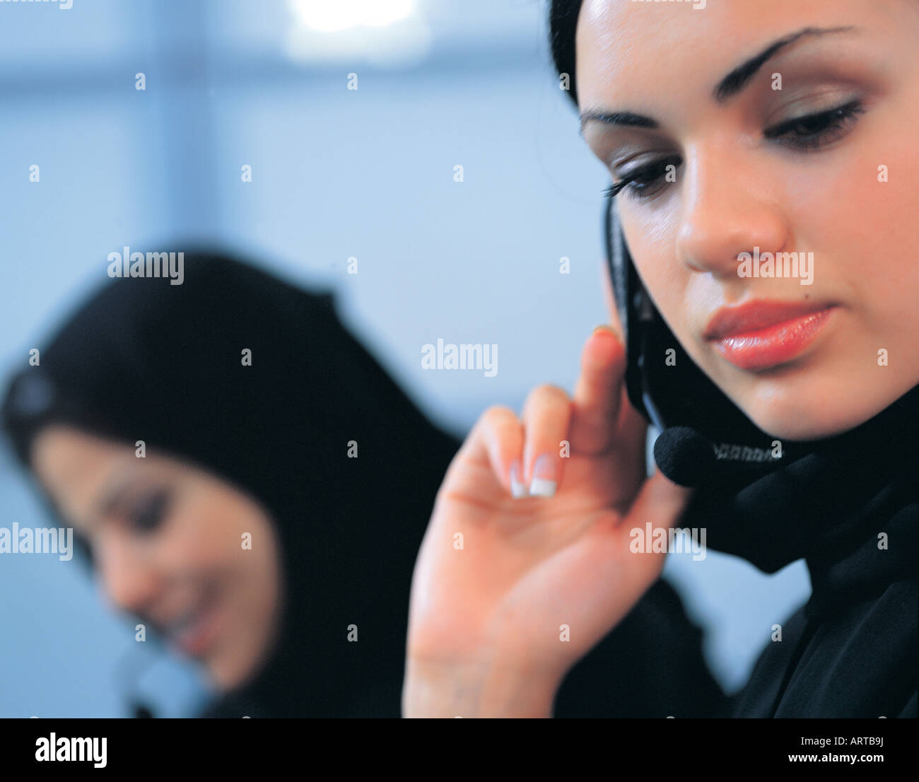 Arab women wearing telephone headsets Stock Photo - Alamy