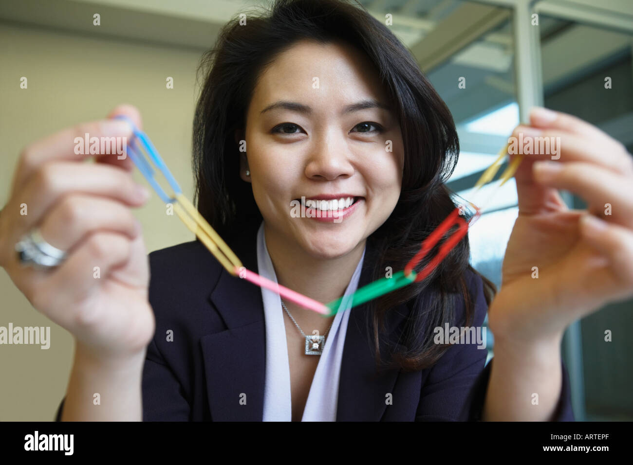 Woman holding paperclips Stock Photo - Alamy