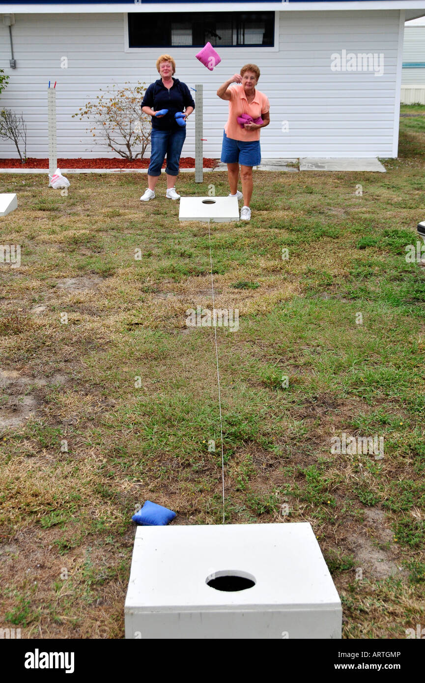 Female Senior Retired Citizens Play Game Of Bean Bag Toss In A Recreational Vechile Camping Park