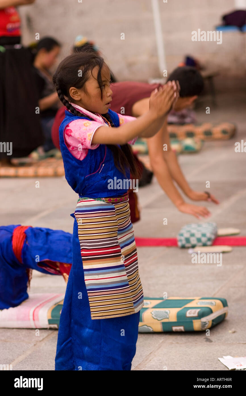 Tibetan girl prostrating in front of the Jokhang Temple, Lhasa Stock ...