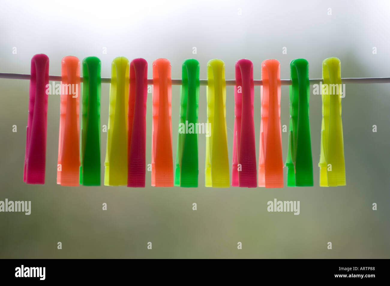 Multi Coloured Plastic pegs on a washing line Stock Photo - Alamy