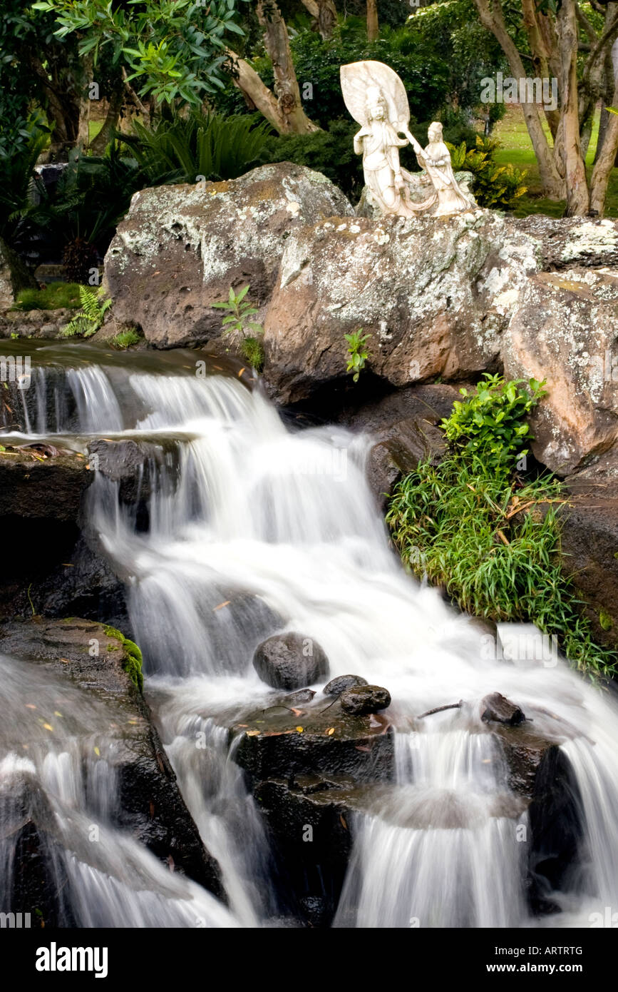 Peaceful waterfall with Asian statues overlooking falls Stock Photo - Alamy