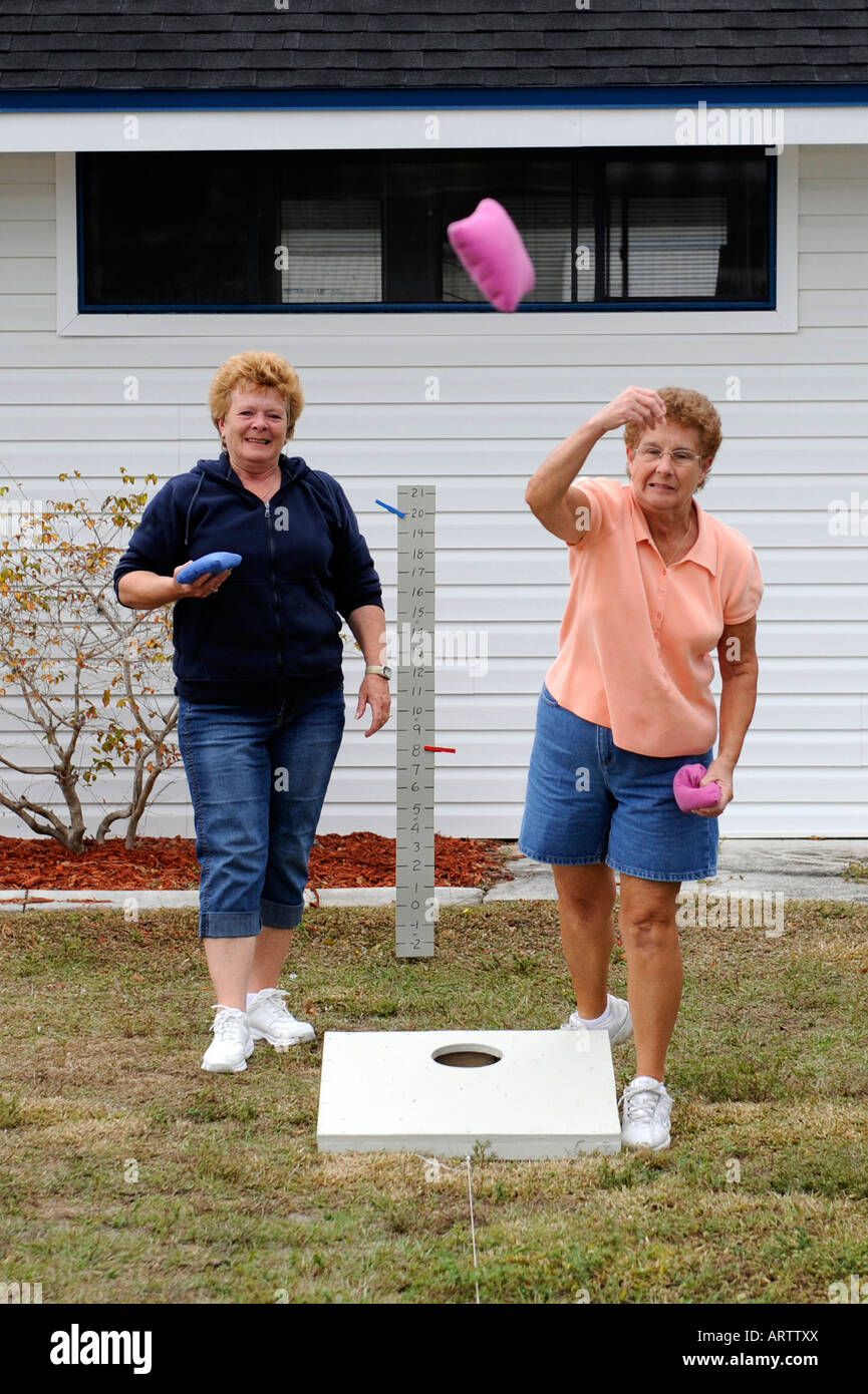Female Senior Retired Citizens Play Game Of Bean Bag Toss In A Recreational Vechile Camping Park
