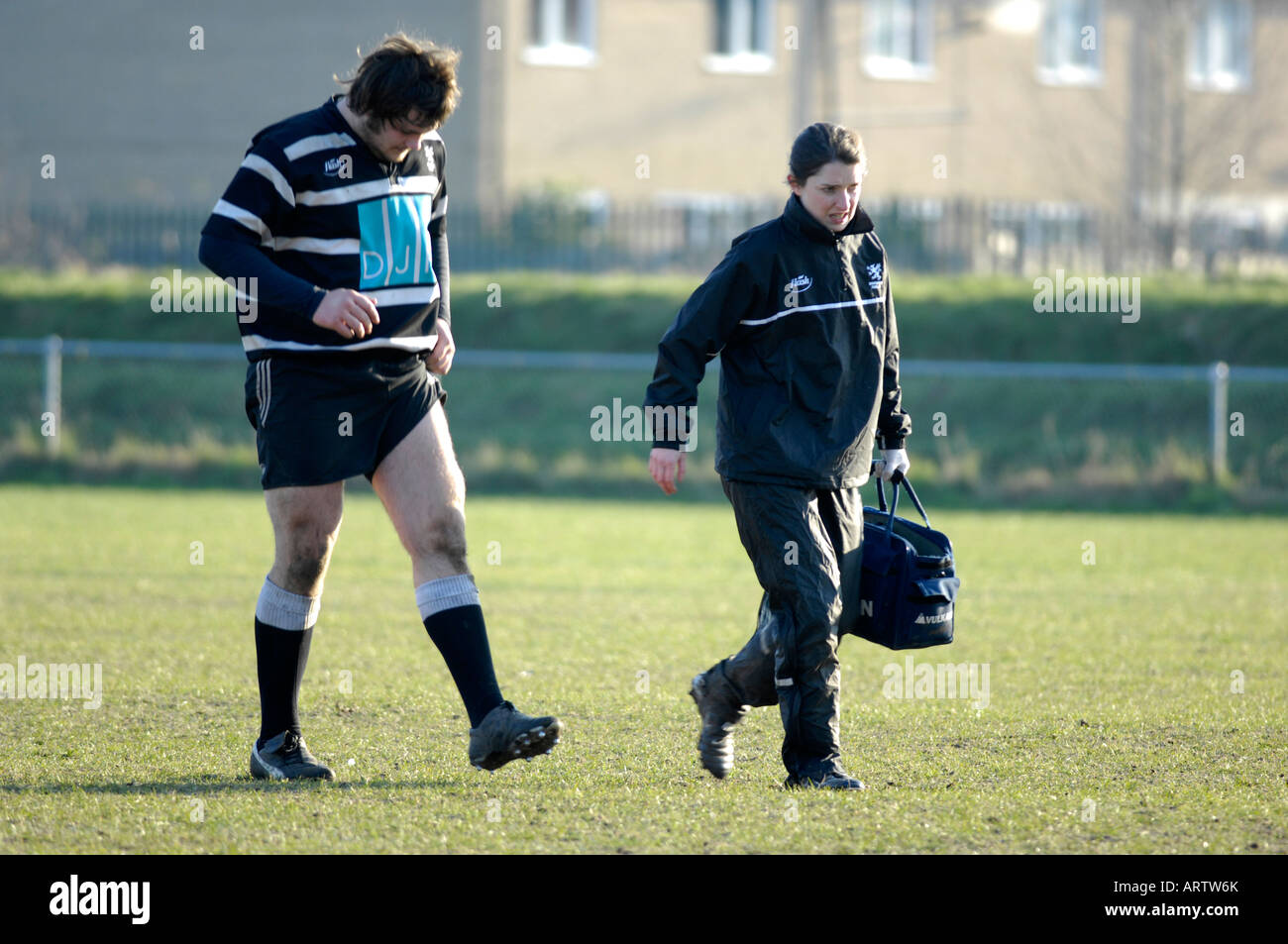 rugby player leaves field with leg injury accompanied by ...