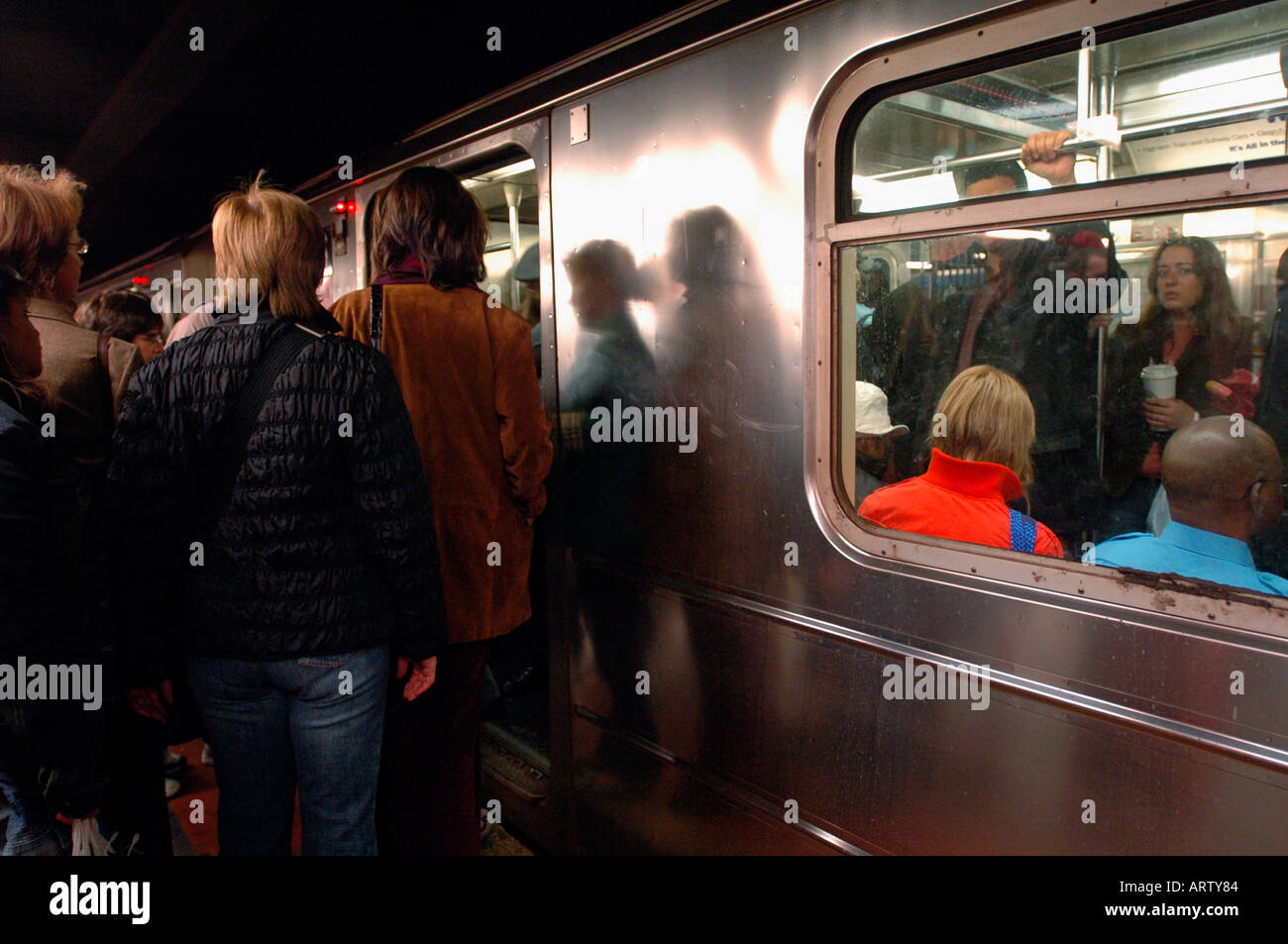 Commuters enter a crowded subway car during rush hour at Times Square ...