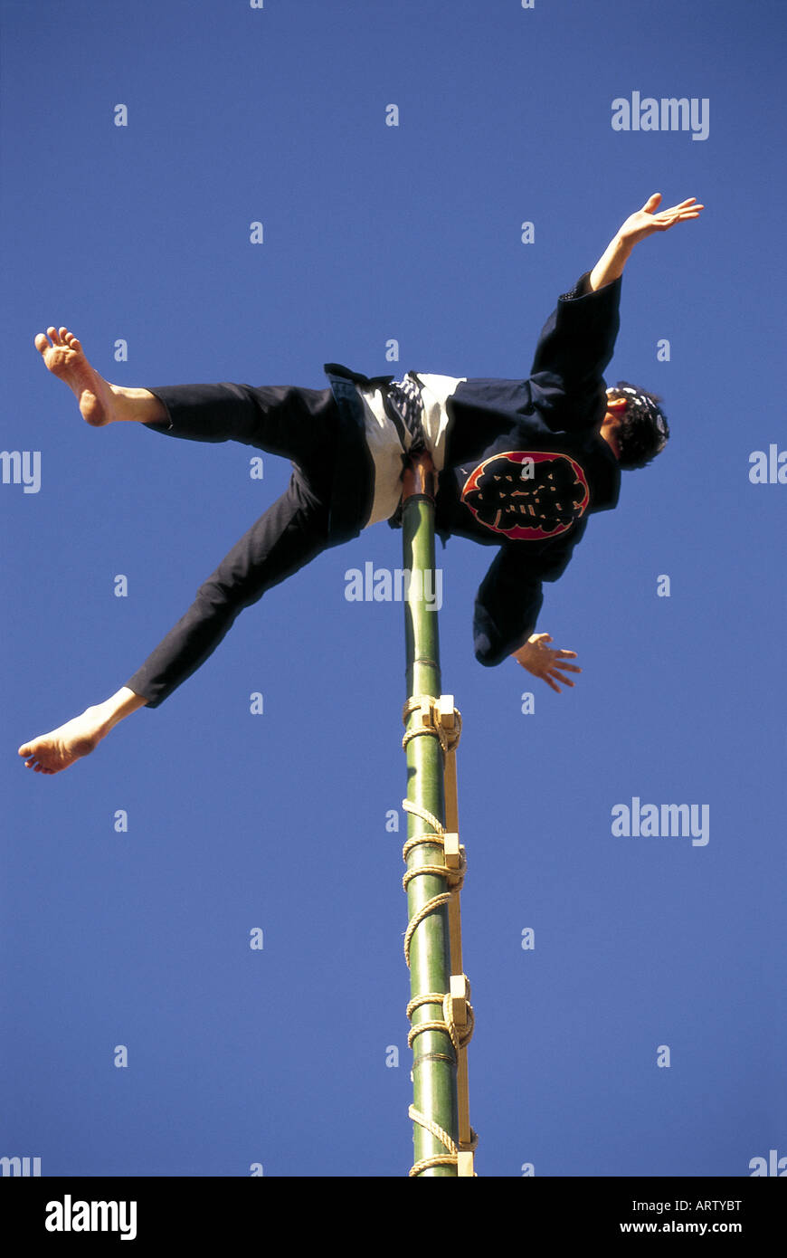 Japanese fireman in traditional costume performing ladder-acrobatics at ...