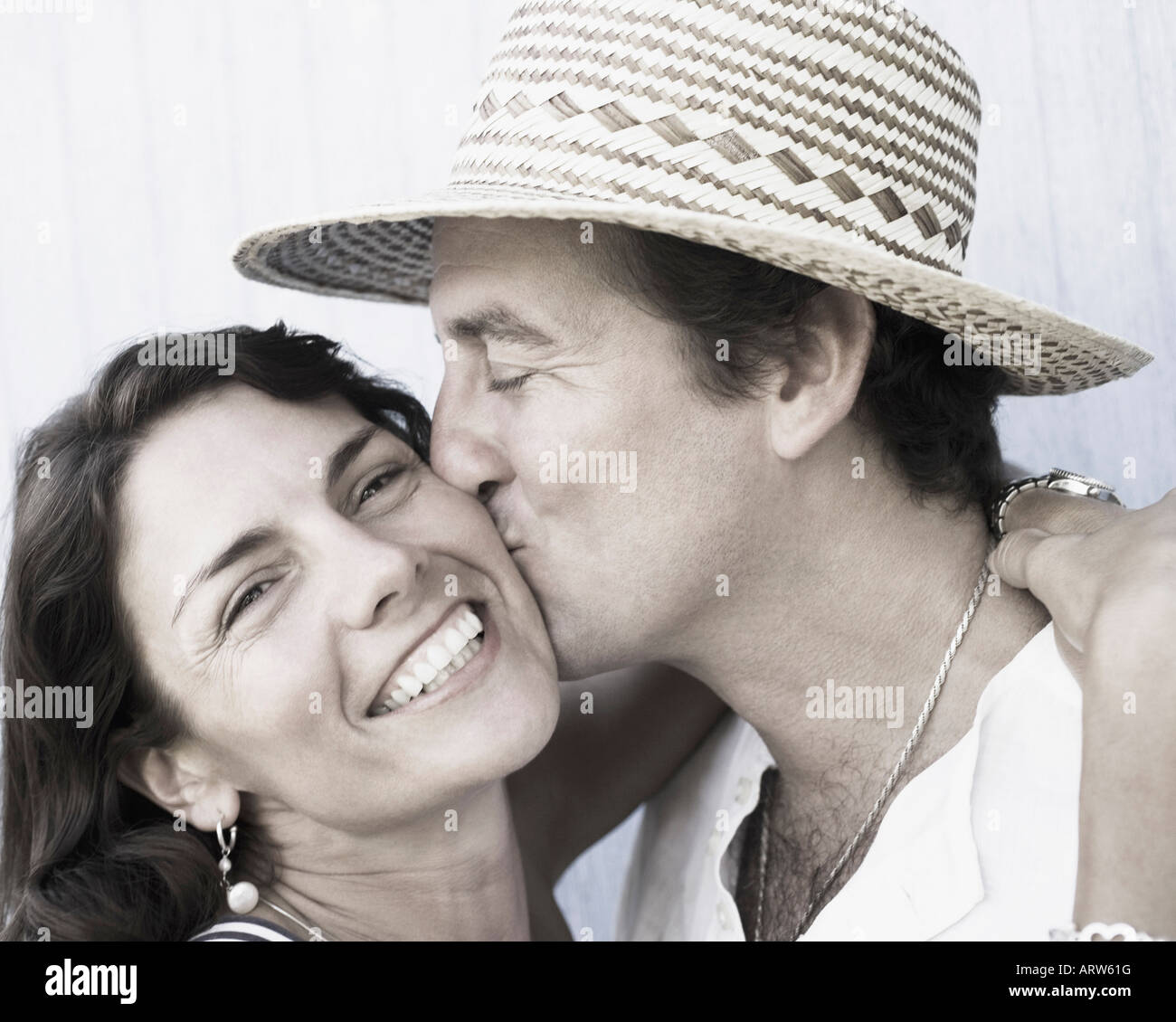 Close-up of a mid adult man kissing a mid adult woman Stock Photo - Alamy