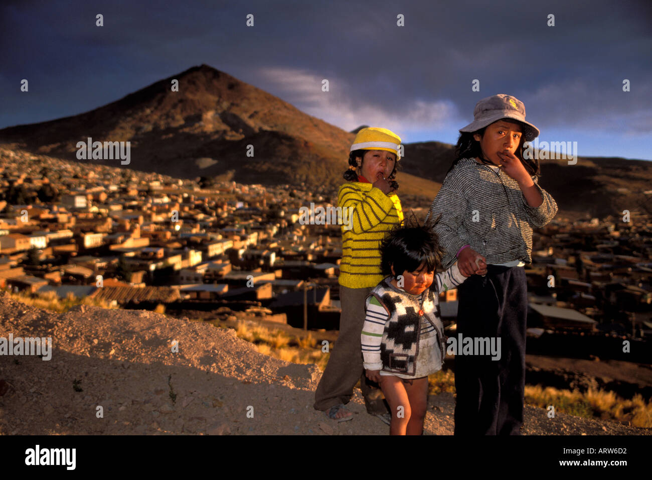 native bolivian children in front of potosi and cerro rico at sunset ...