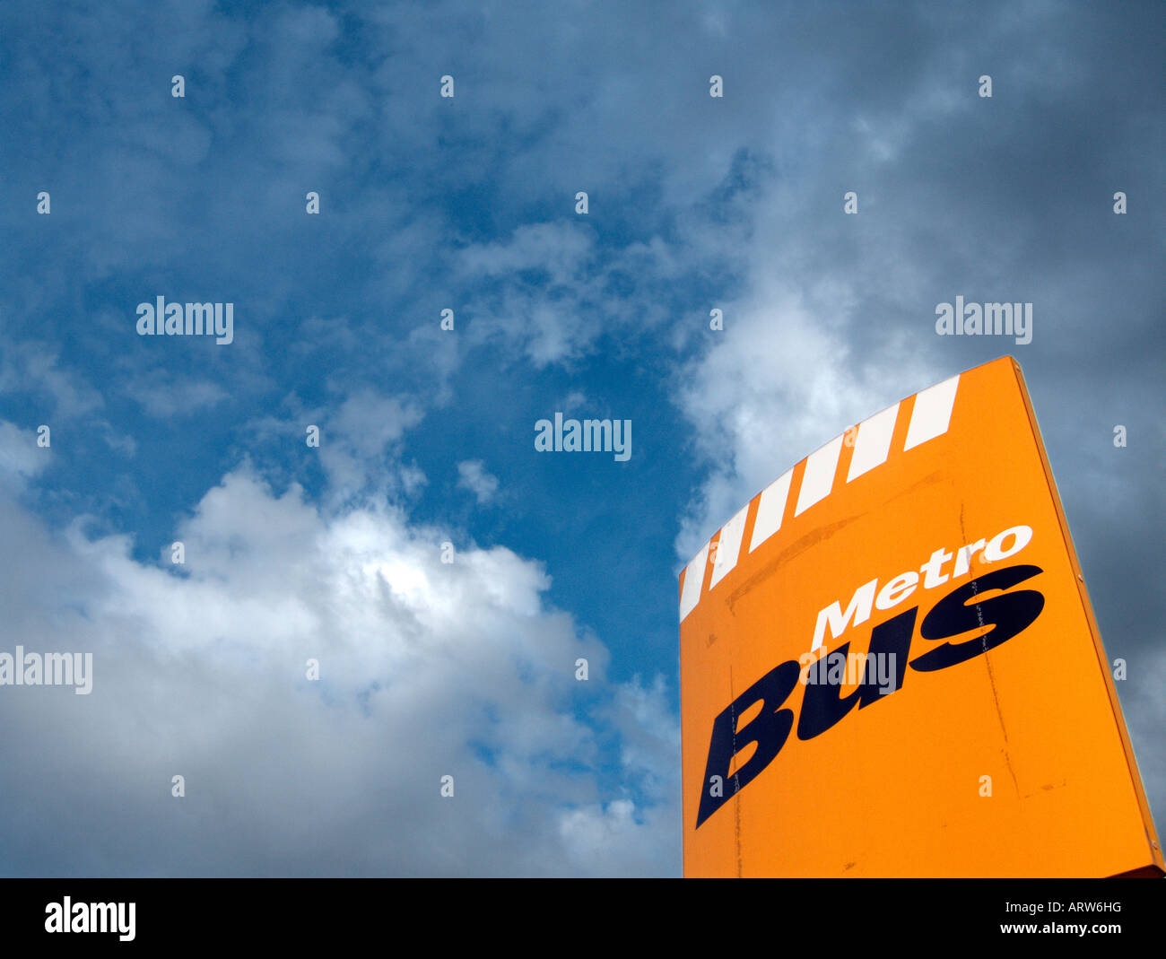 Orange bus-stop signal against a blue cloudy sky Stock Photo - Alamy
