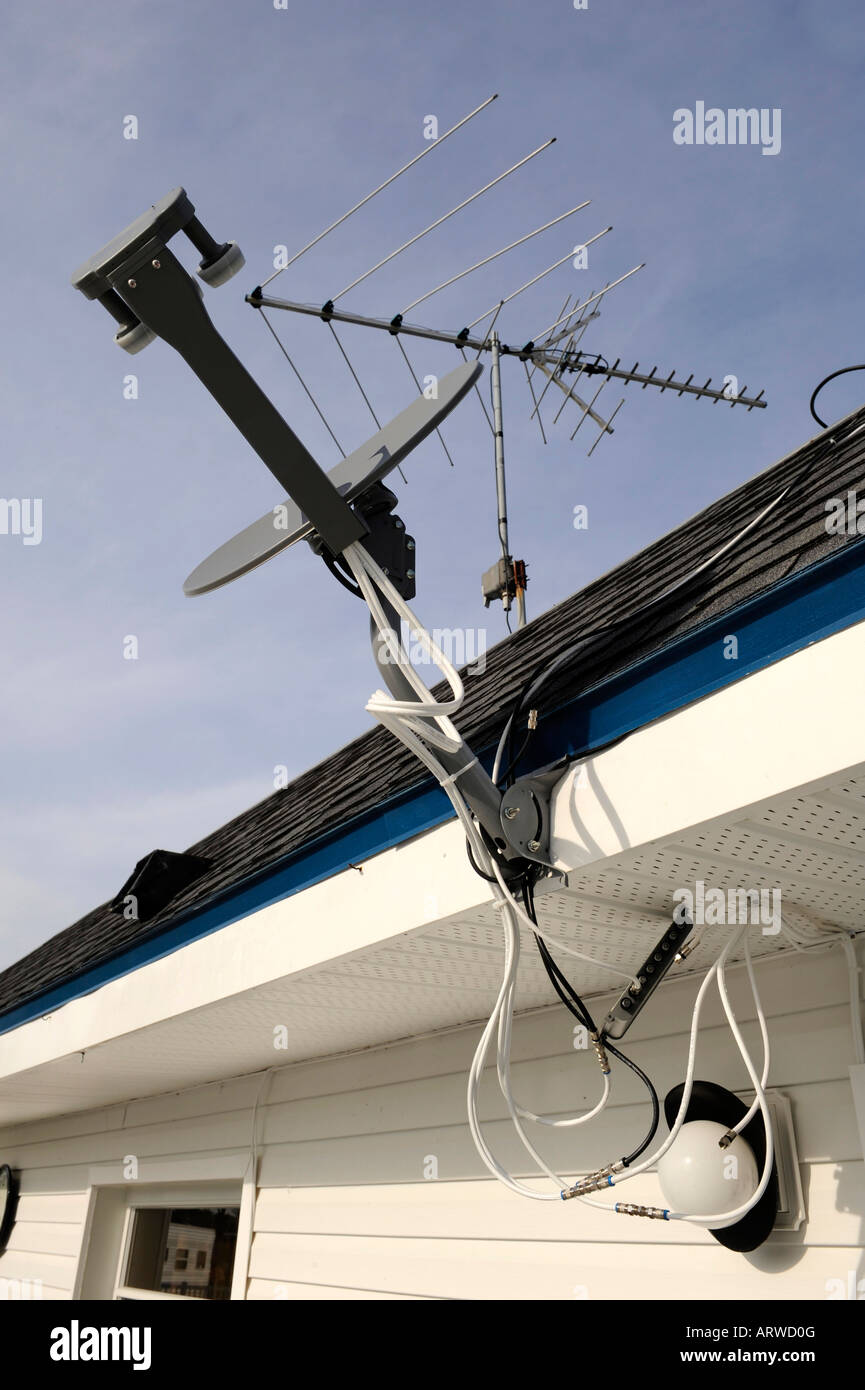 Satellite dish and old technology television antenna on a roof Stock ...