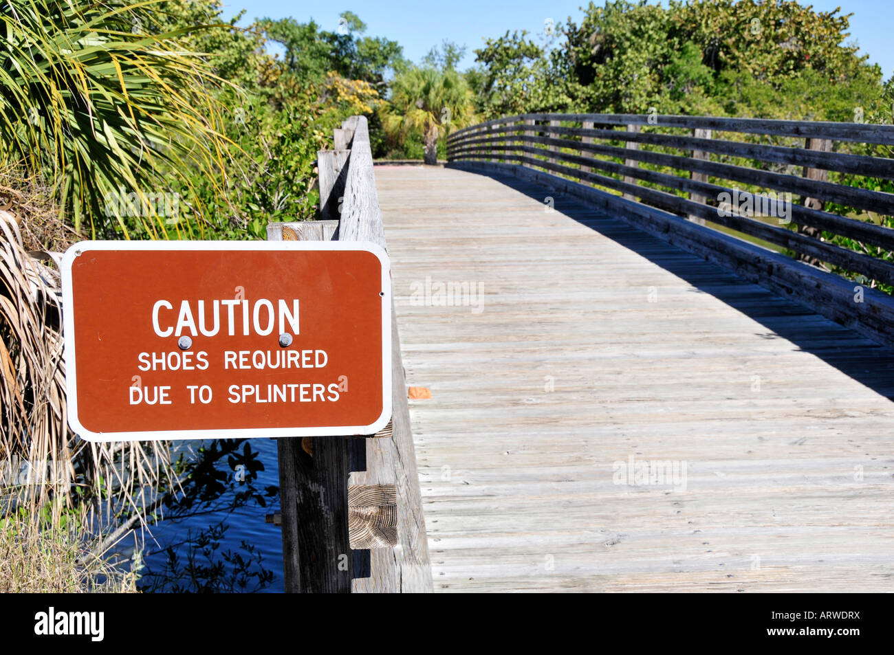 Warning sign on wood bridge across river at Lovers Key State Park ...