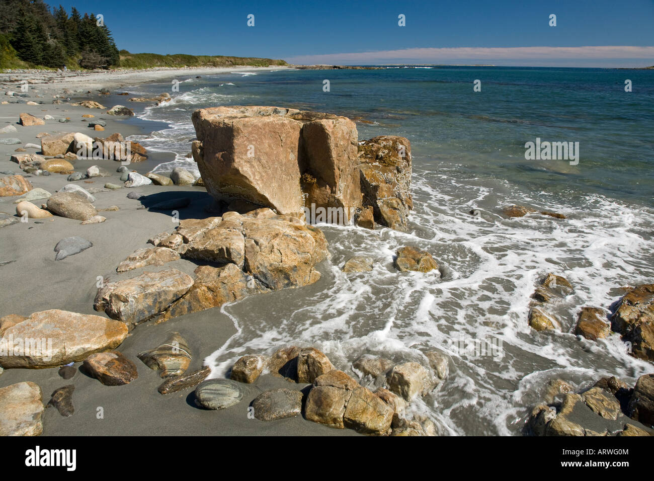 Waves lap around the rocks on the beautiful curve of South Sandy Beach ...