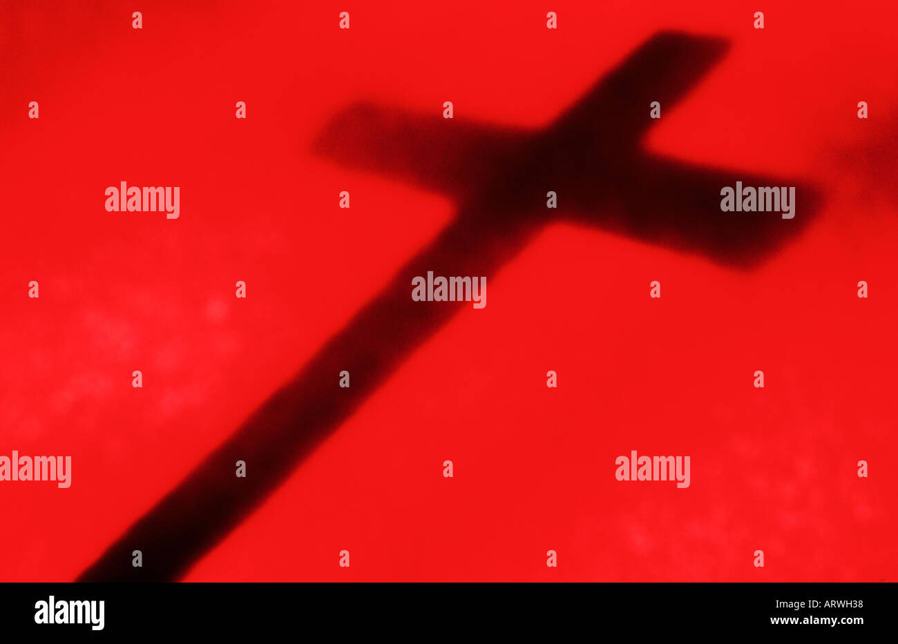 Shadow of a crucifix falling at an angle across a blood red surface ...