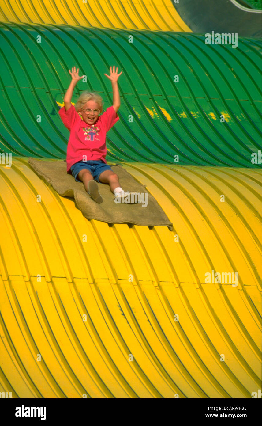 Girl age 7 raising hands riding giant slide at the Minnesota State Fair ...