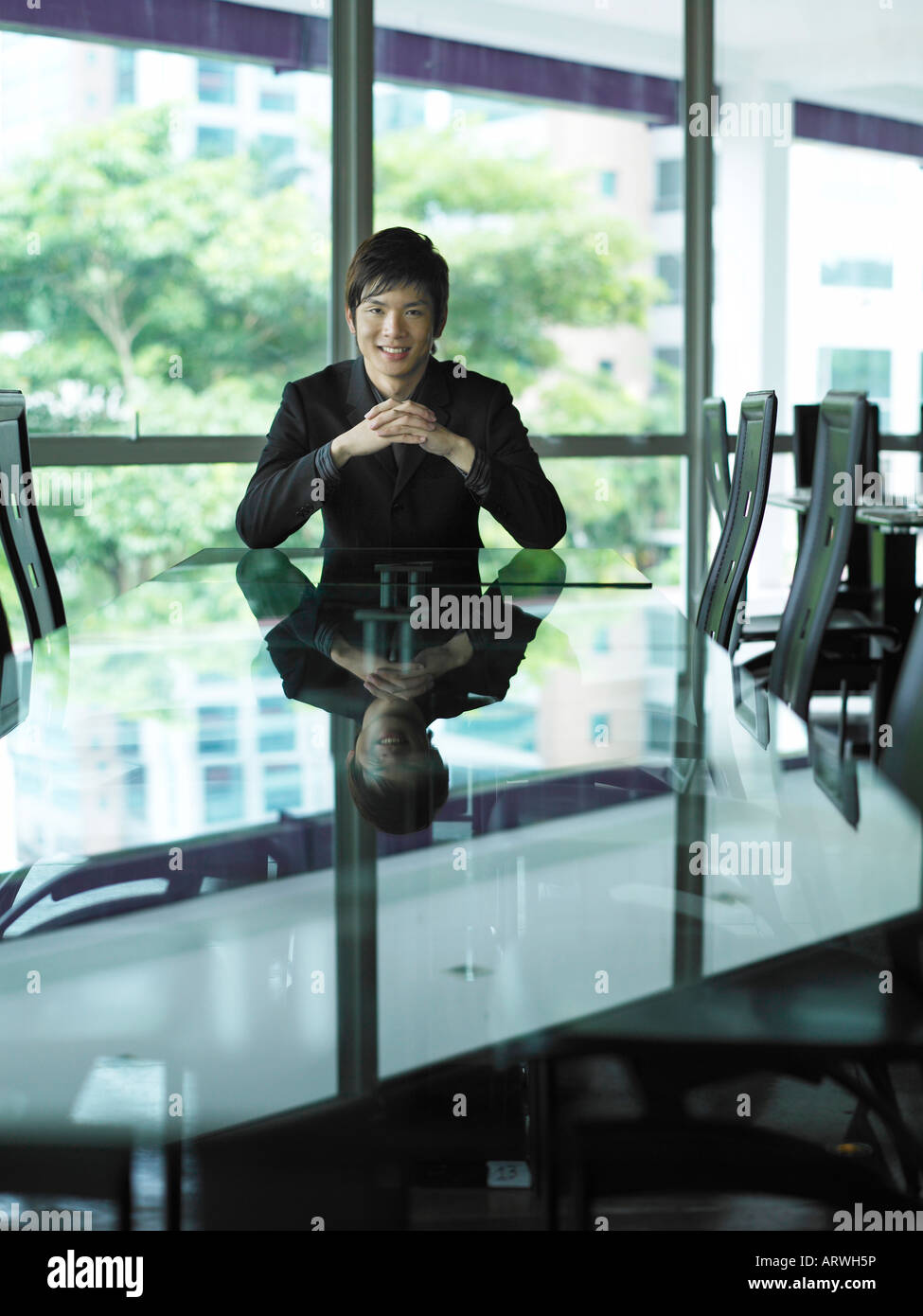 Business Executive Sitting Alone at Head of Conference Table Stock ...