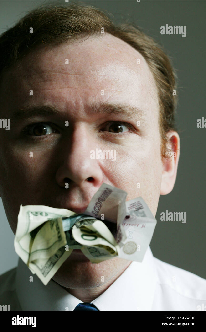 Man with money stuffed in his mouth Stock Photo - Alamy