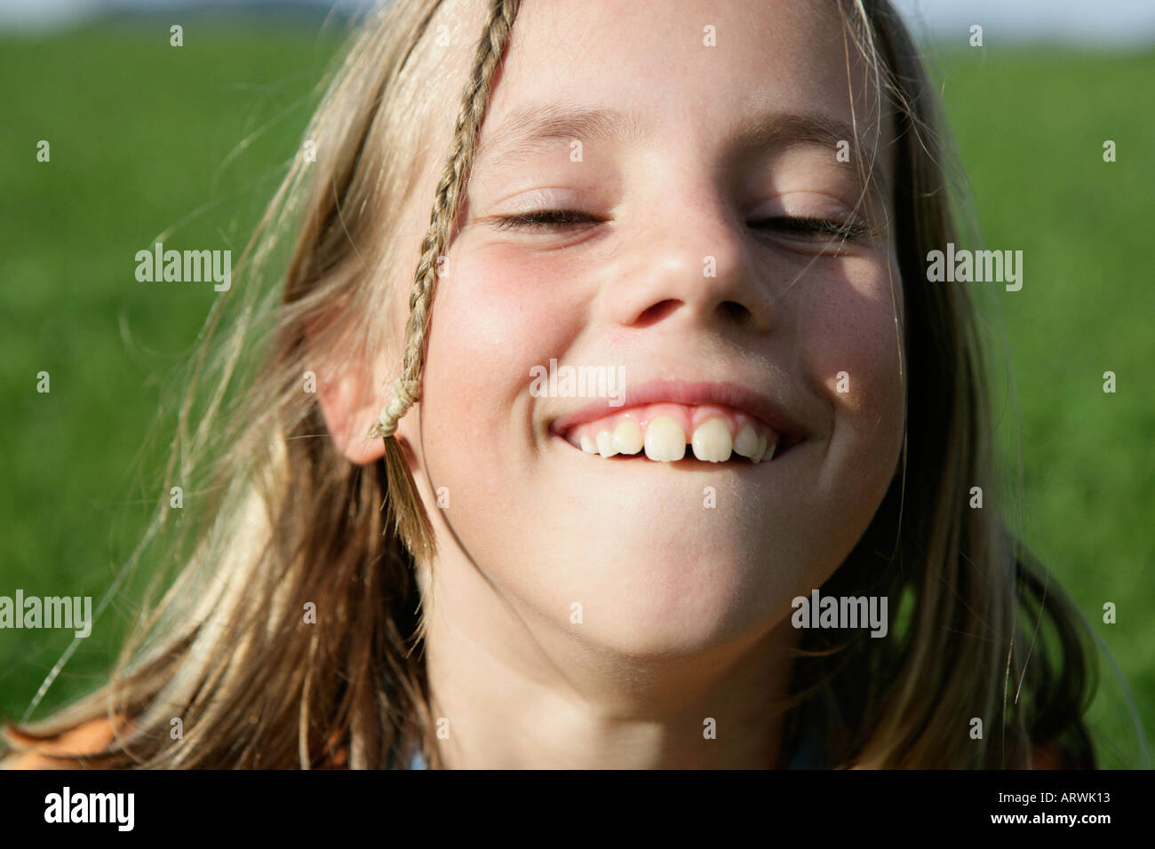 Young blonde girls showing her teeth Stock Photo - Alamy