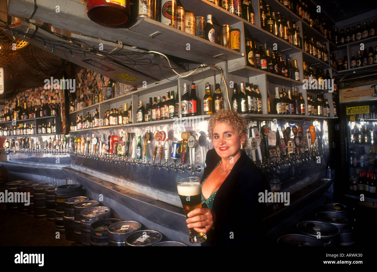 Female proprietor of tavern offers an ale in front of multiple taps in ...