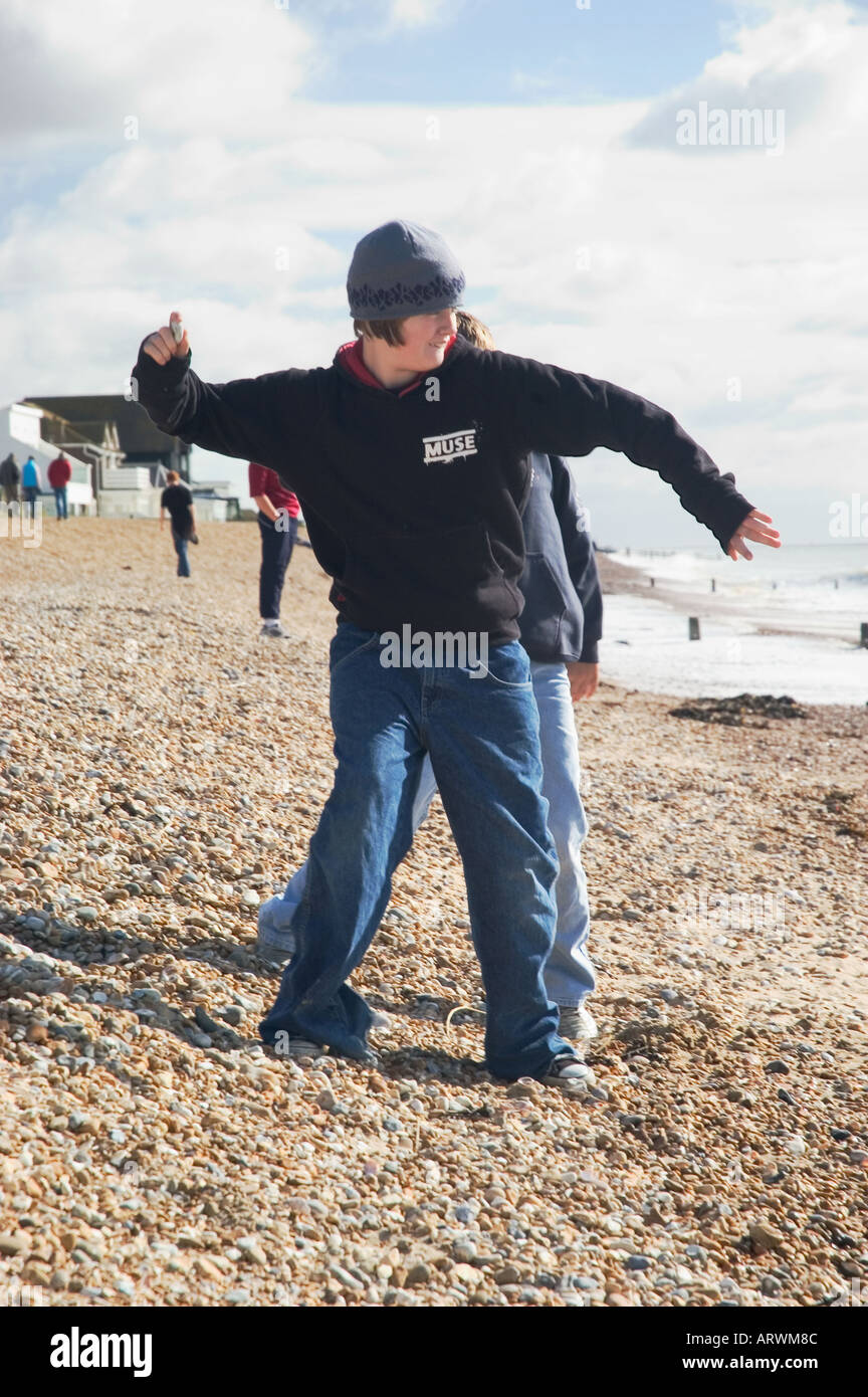 A teenager throwing a stone at the seaside Stock Photo - Alamy
