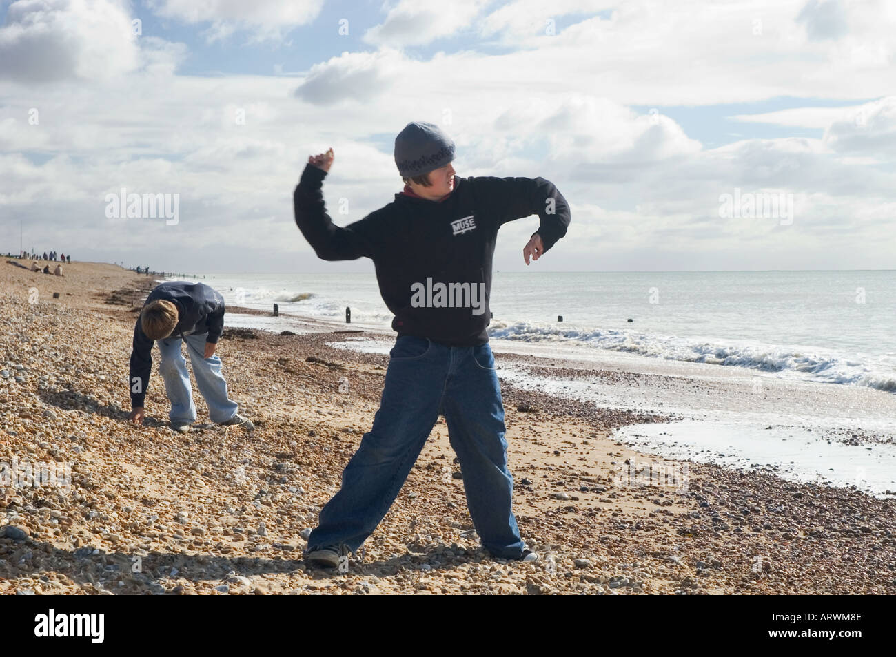 A teenager throwing a stone at the seaside Stock Photo - Alamy