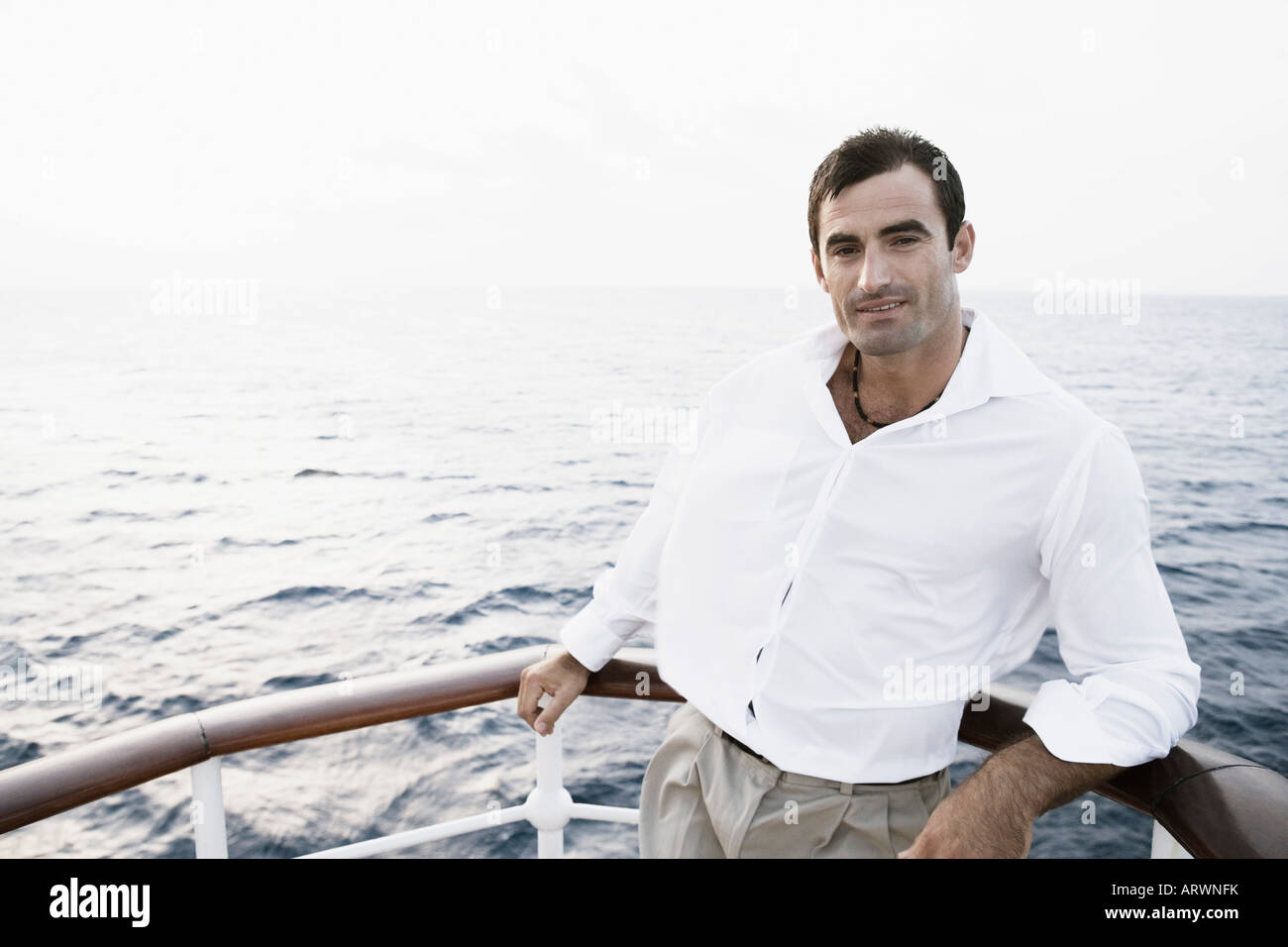 Portrait of a mid adult man leaning against the railing of a boat Stock ...